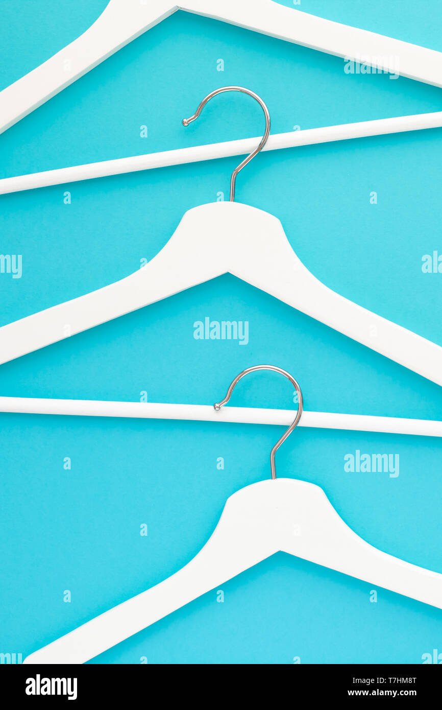 Creative top view flat lay white wooden hangers isolated bold blue ...