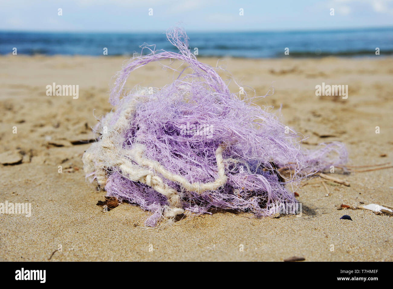 Fishing nylon net on the sand. Garbage on the beach. Dirty sea shore ...
