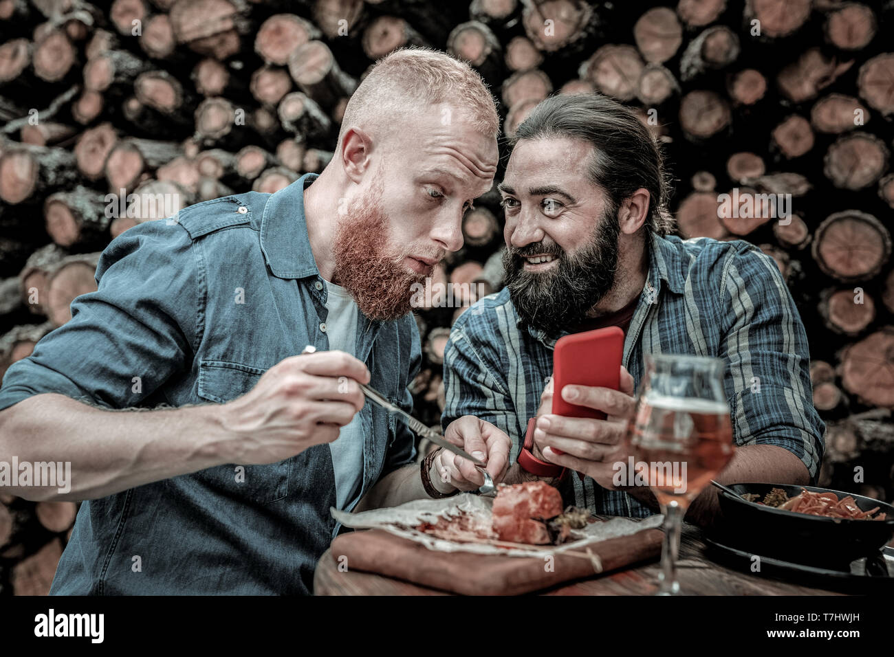 Friends eating together in front of fire wood Stock Photo - Alamy