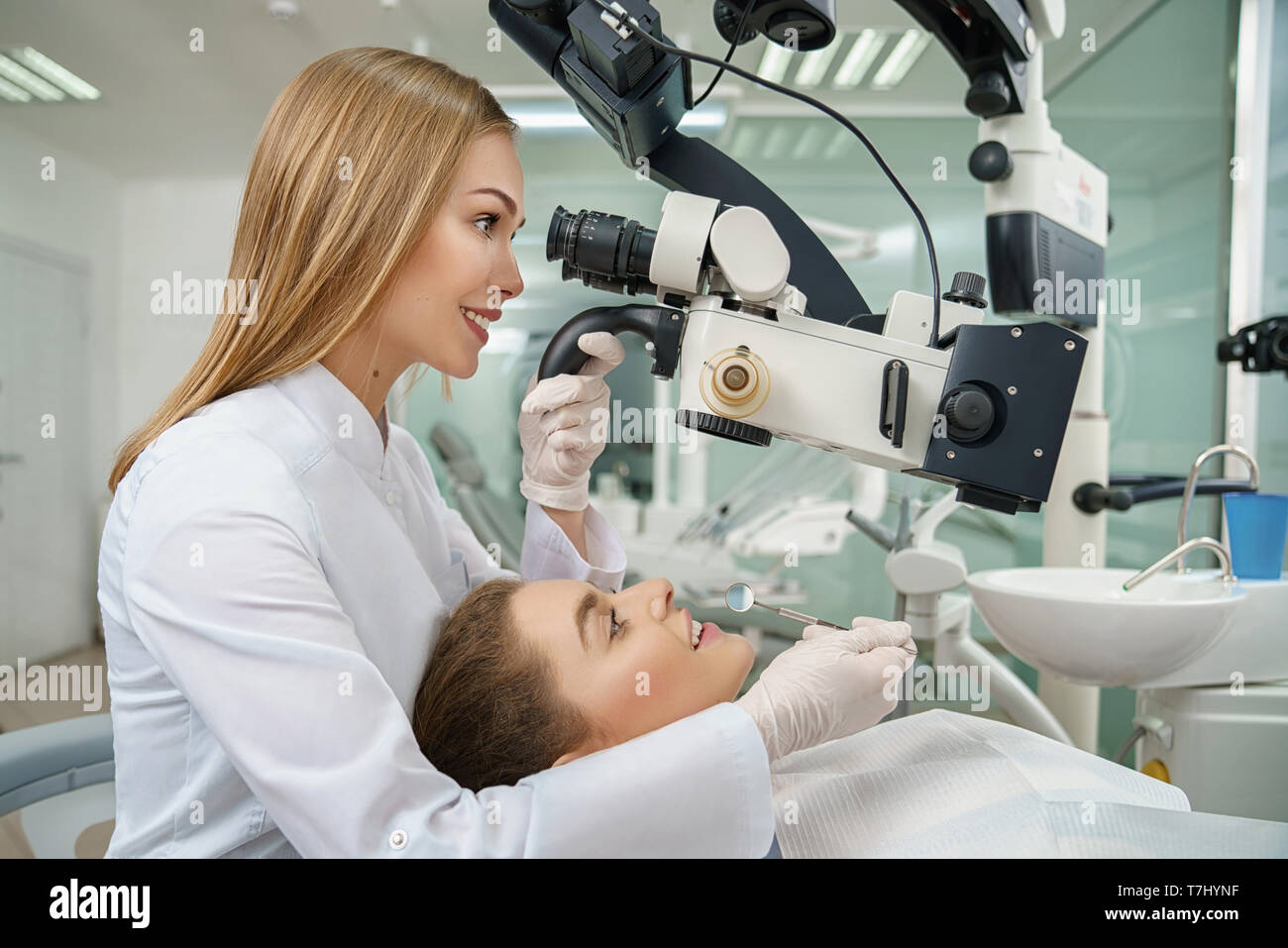 Side view of experienced female dentist looking at professional ...
