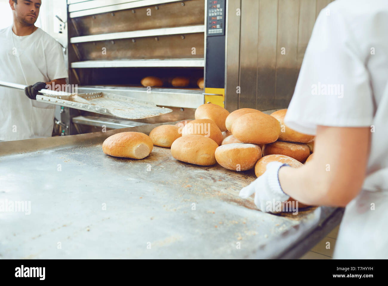 Bakers take out bread from the oven in the bakery Stock Photo - Alamy