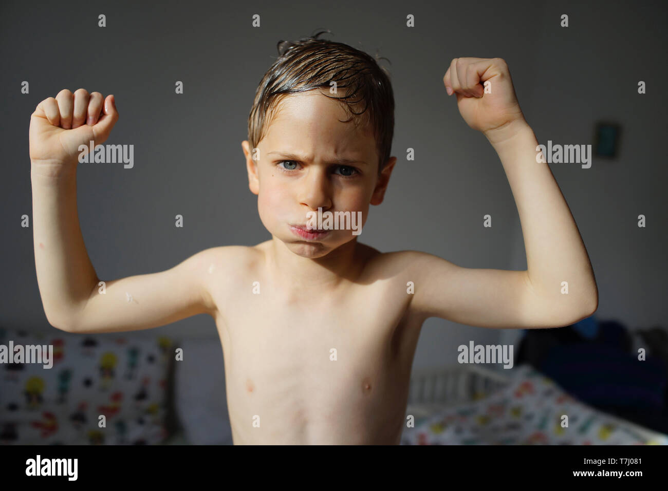 Little boy pulling funny face, showing muscles Stock Photo - Alamy