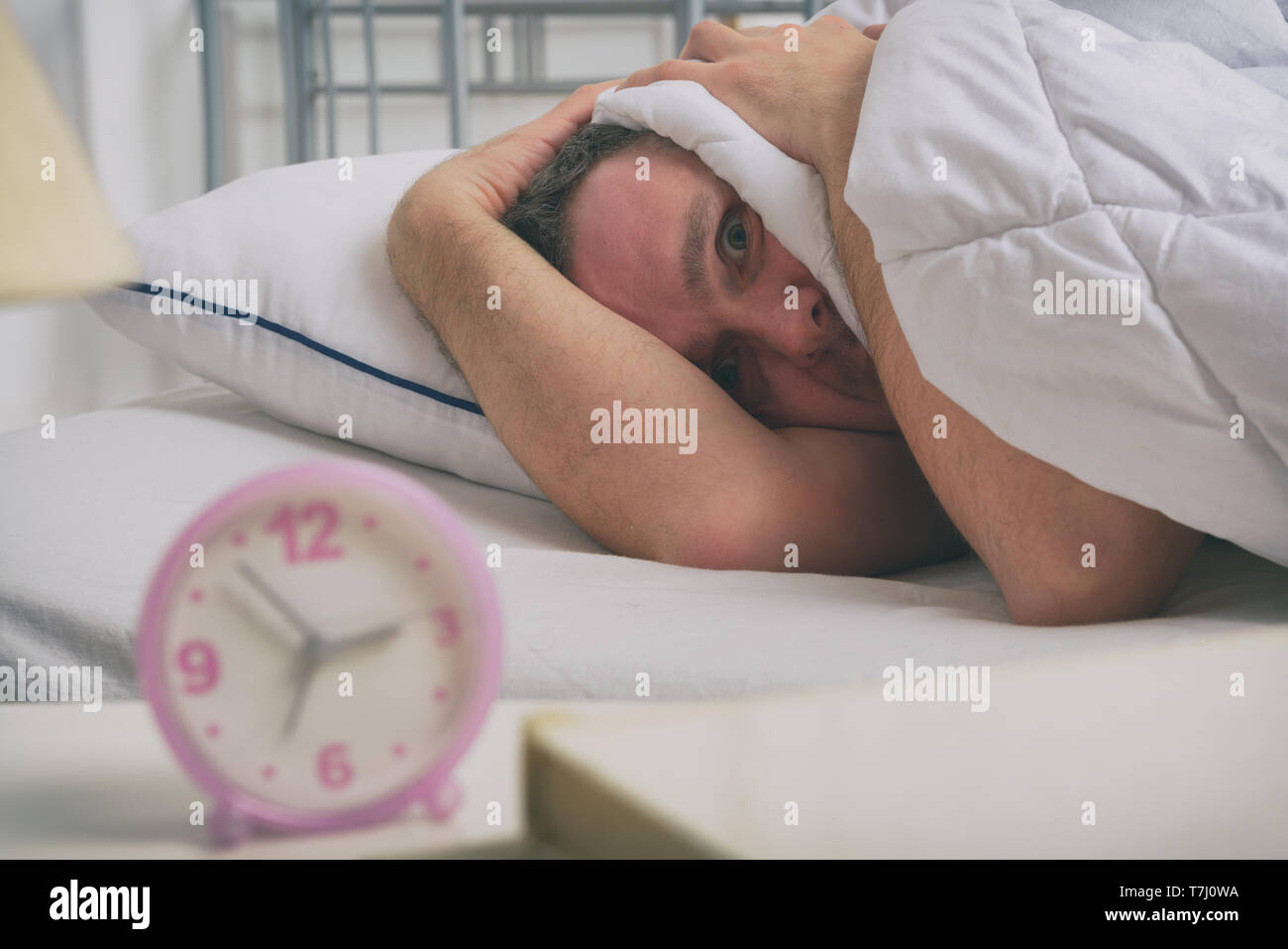 Sleepless, awaken man in bed at home Stock Photo - Alamy