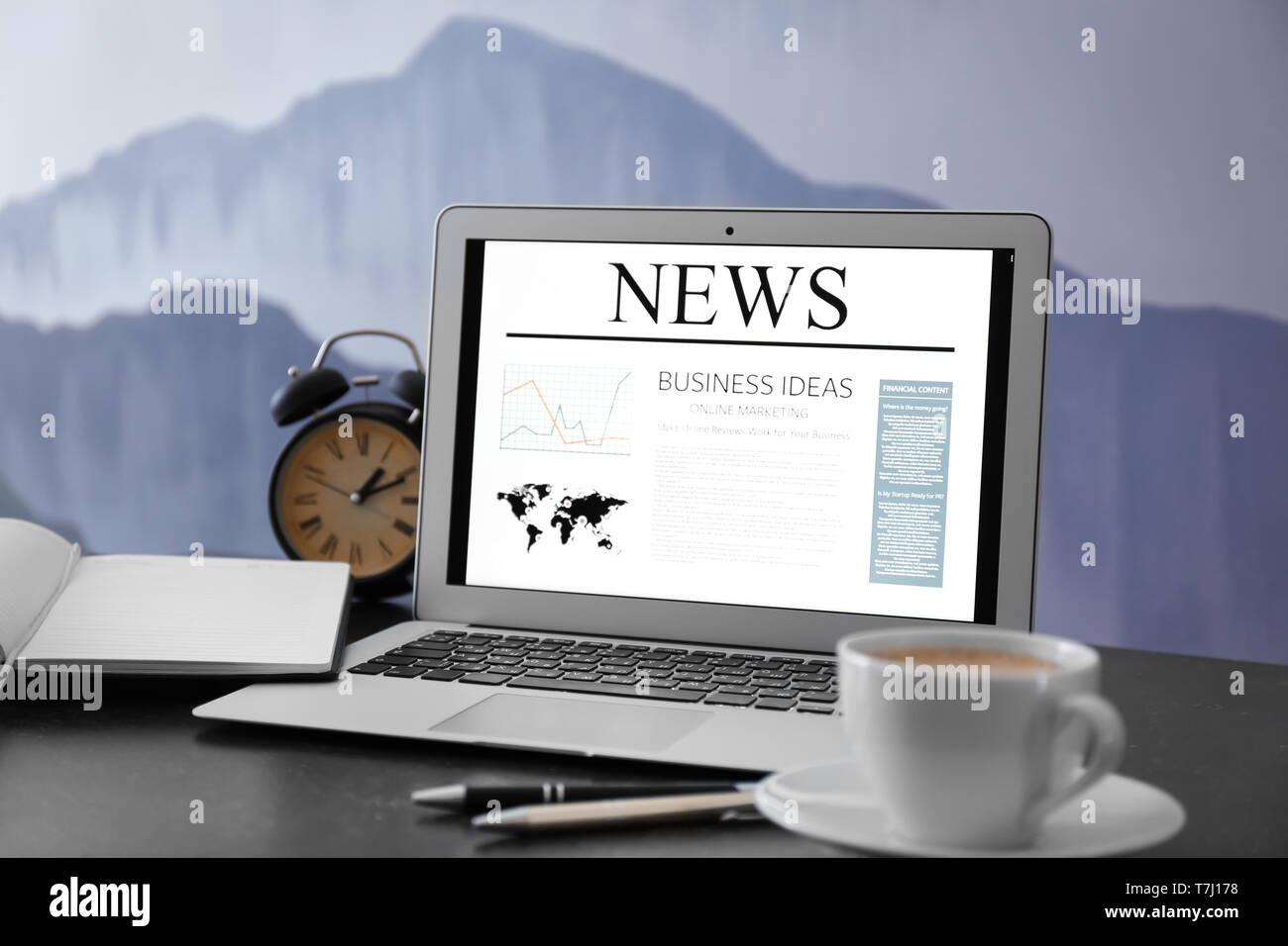 Workplace with laptop and news on screen Stock Photo - Alamy