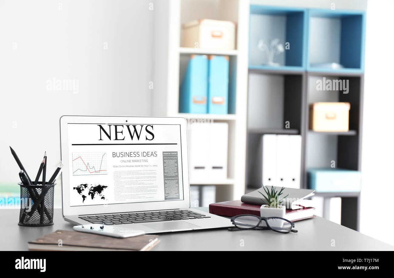 Workplace with laptop and news on screen Stock Photo - Alamy