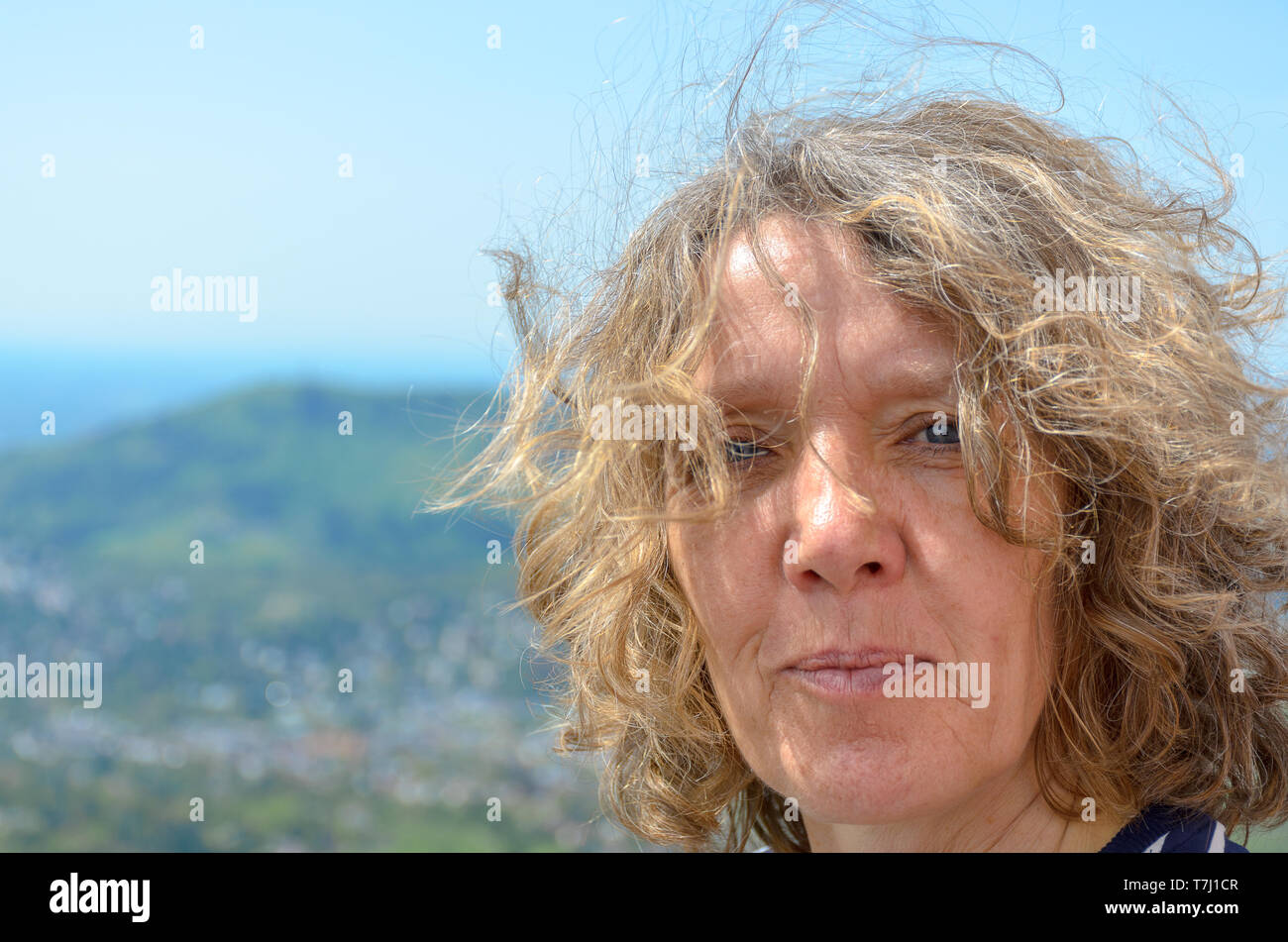 Close-up portrait of a middle-aged woman with blond hair and blue eyes ...