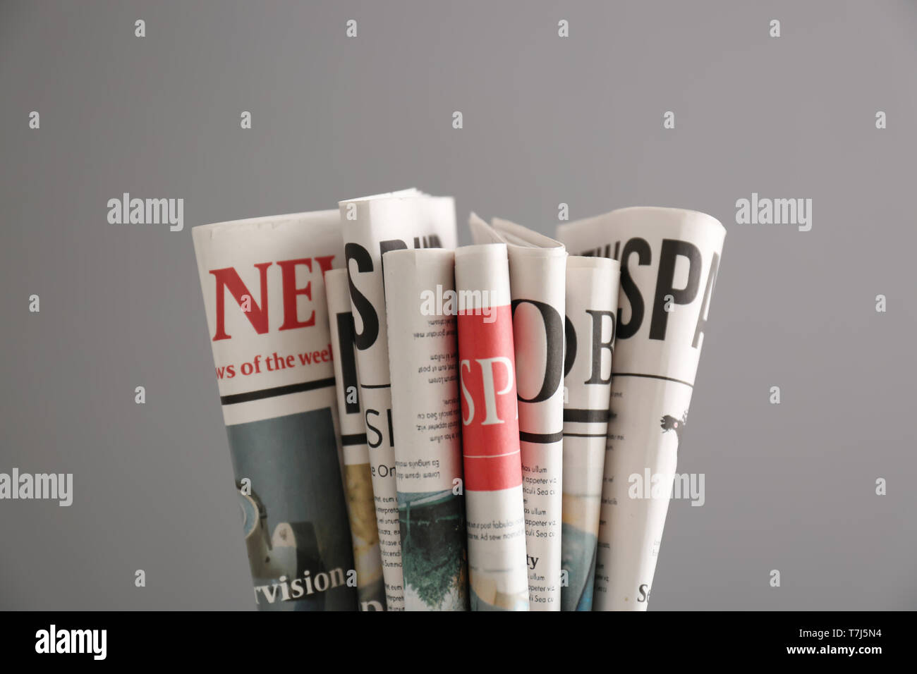 Newspapers on grey background Stock Photo - Alamy