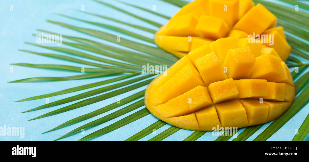 Fresh mango on a palm leaf. Blue background. Close up Stock Photo - Alamy