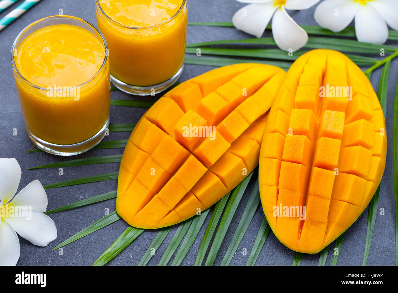 Fresh tropical fruit smoothie mango juice and fresh mango on grey ...