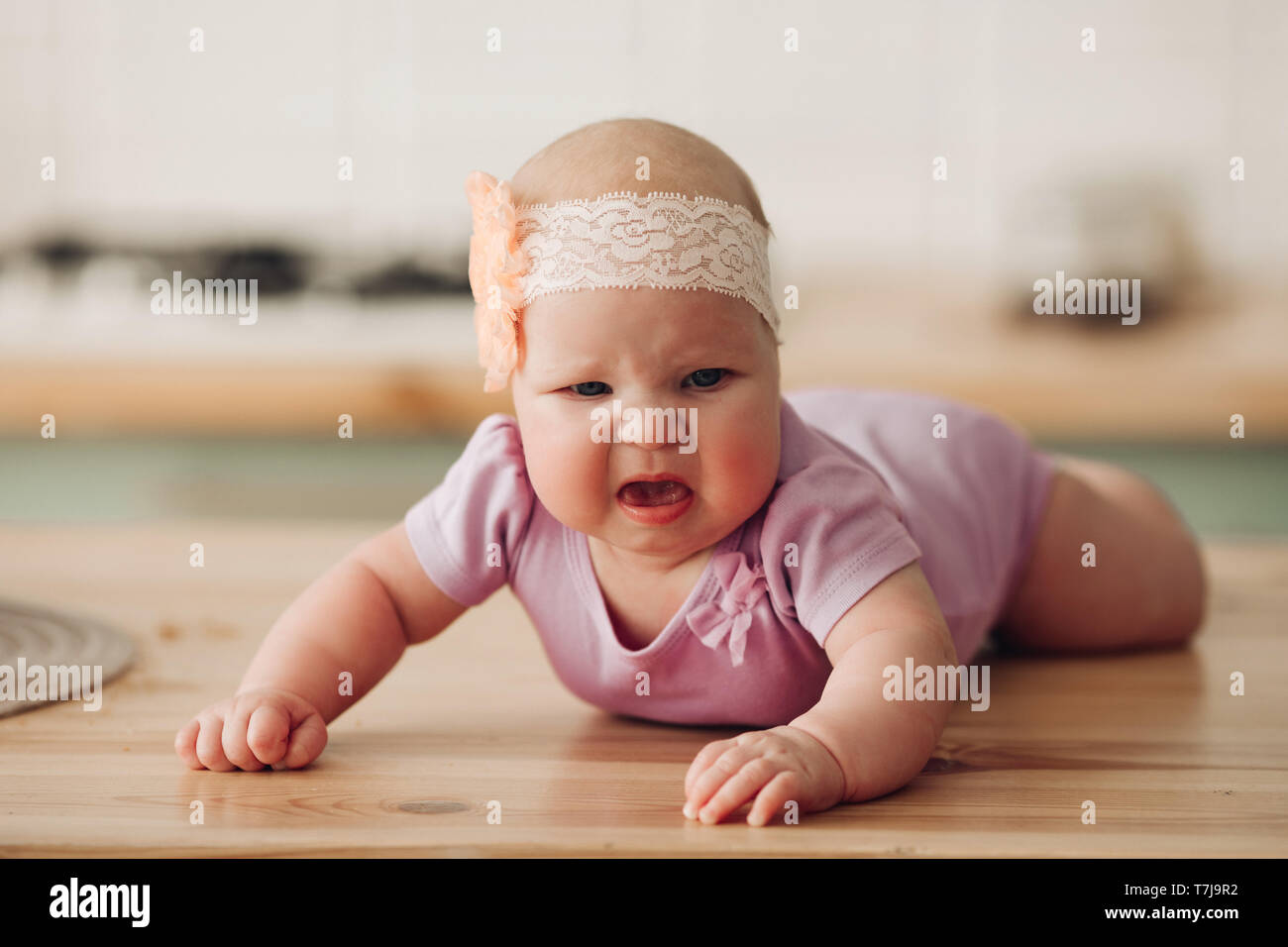 Sad baby lying on floor and crying Stock Photo - Alamy