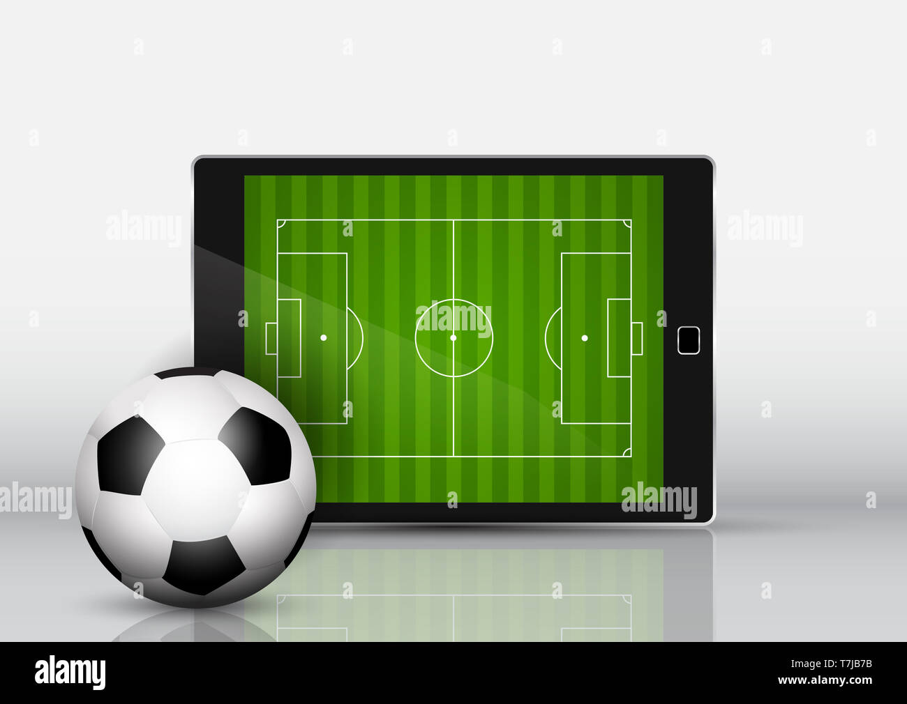 Soccer or football in front of an electronic device with pitch on ...