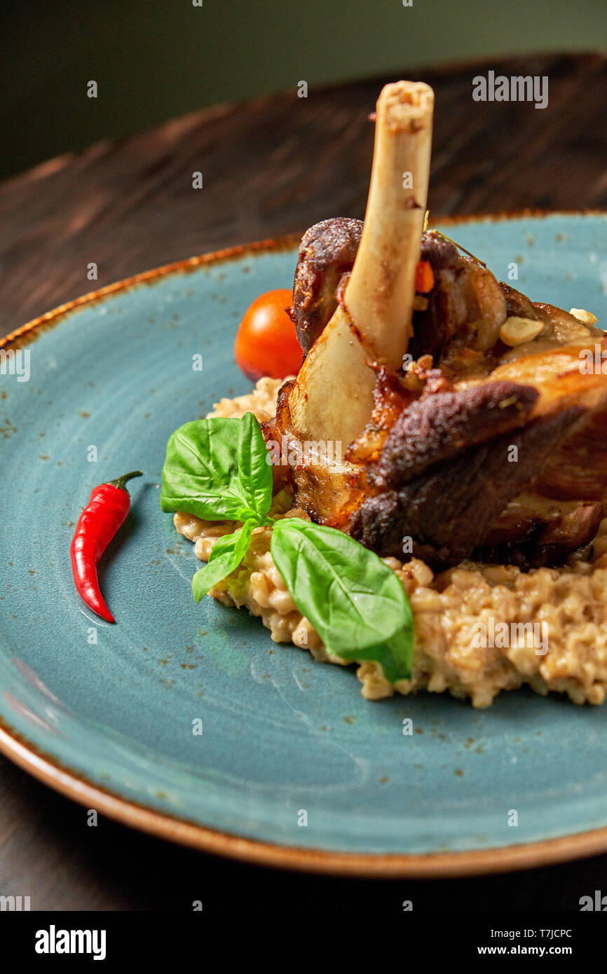 Shredded meat dish with garnish decorated with vegetables on a blue ...