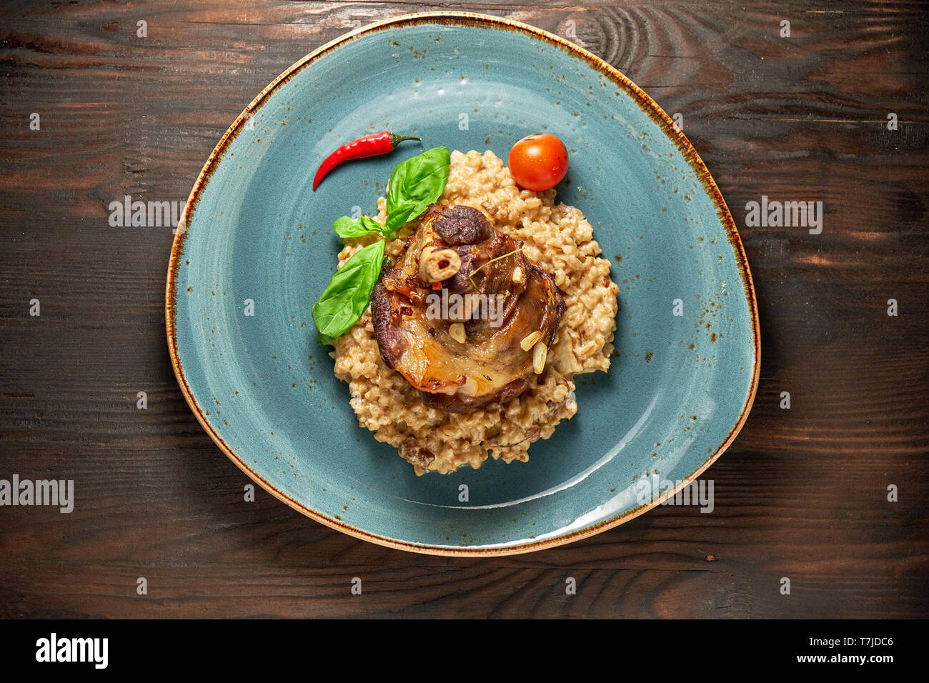 Shredded meat dish with garnish decorated with vegetables on a blue ...