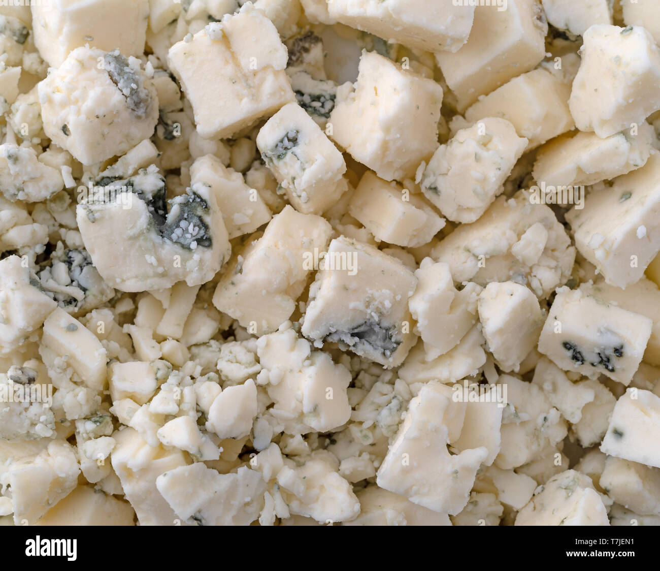 Close view of crumbled blue cheese illuminated with natural lighting ...