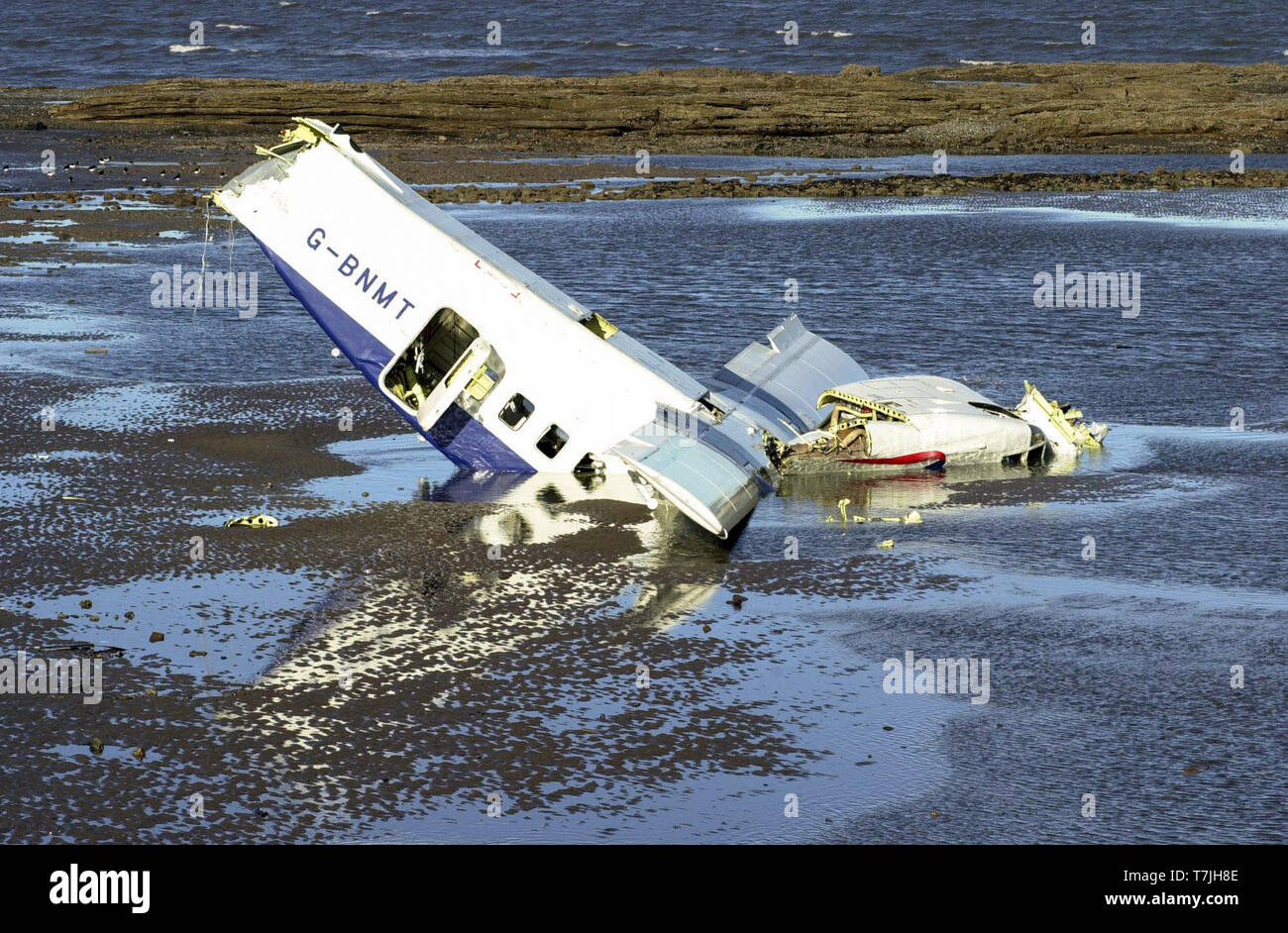Investigators look at the wreckage of the Loganair Short 360 aircraft ...