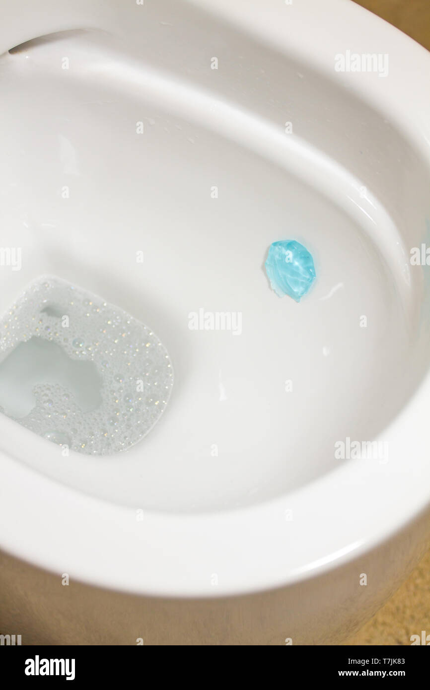Modern toilet bowl with blue detergent for cleaning and disinfection ...
