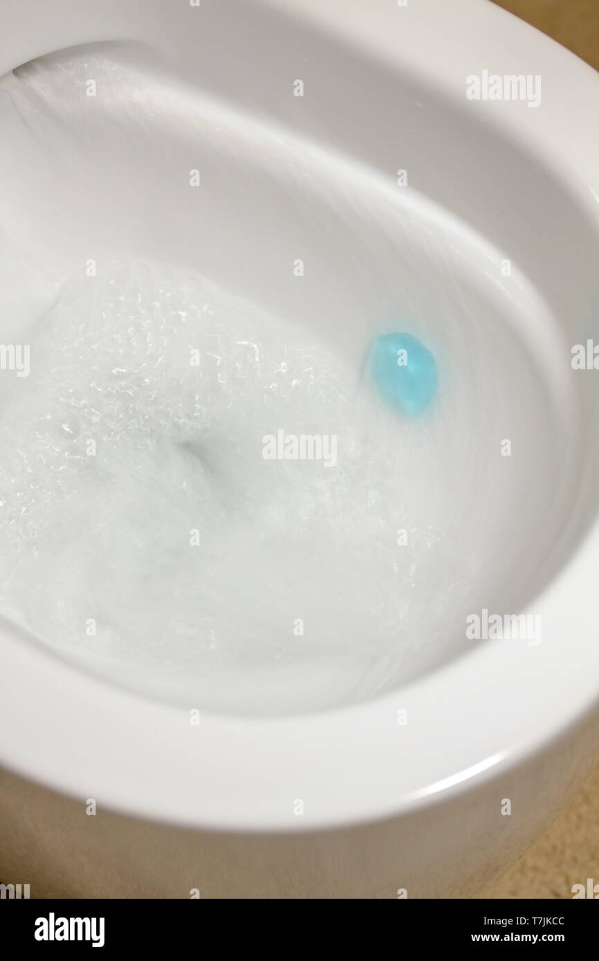 Modern toilet bowl with blue detergent for cleaning and disinfection ...