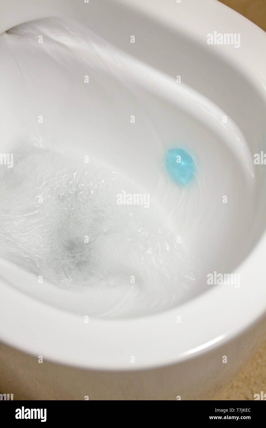Modern toilet bowl with blue detergent for cleaning and disinfection ...