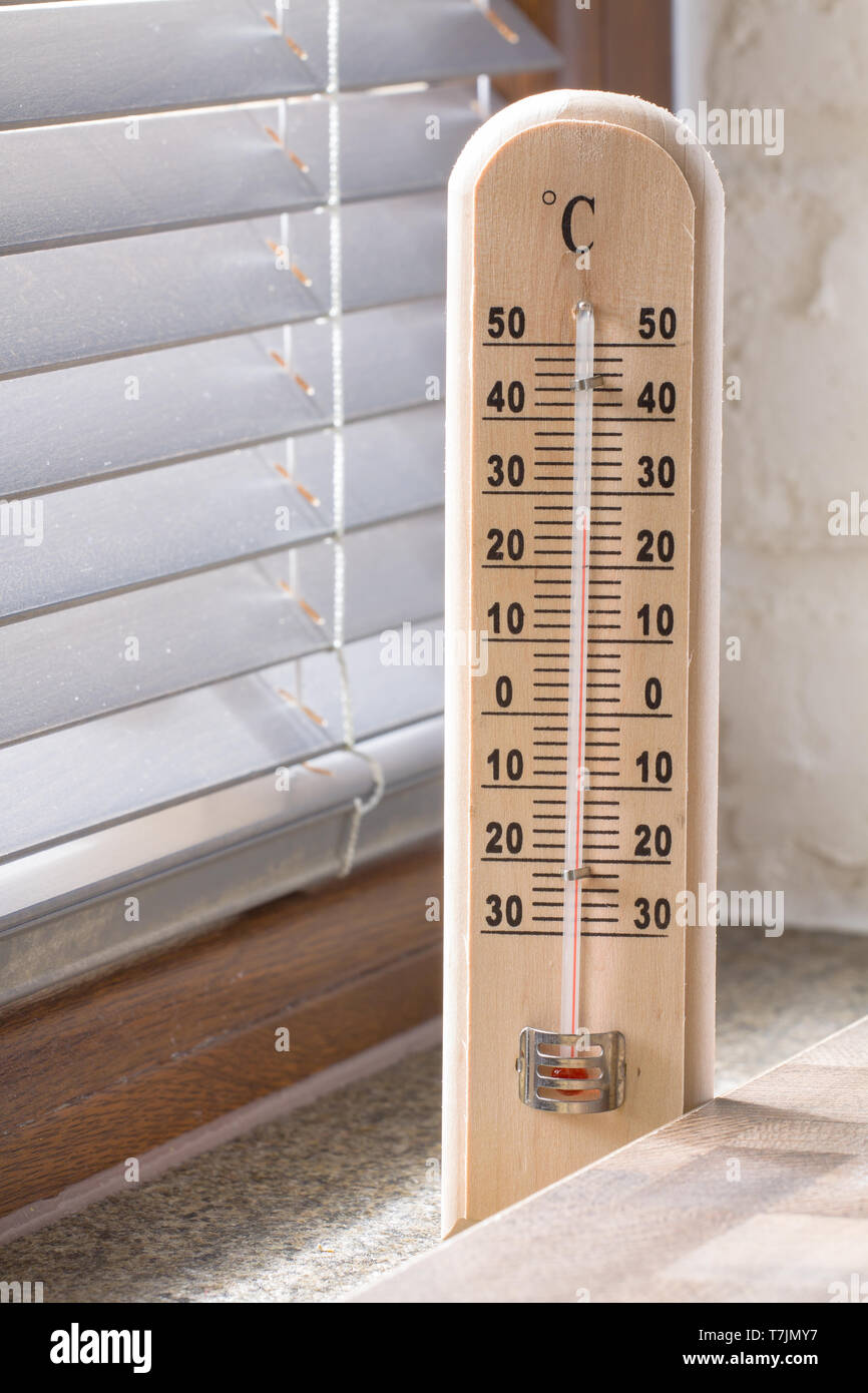 A wooden thermometer with an analog scale measuring the temperature ...