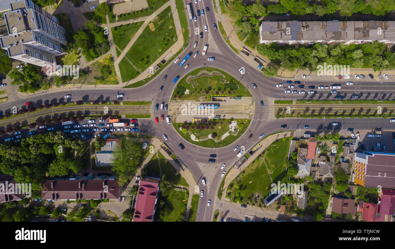 Overhead drone top down shot of busy roundabout with cars and trucks ...