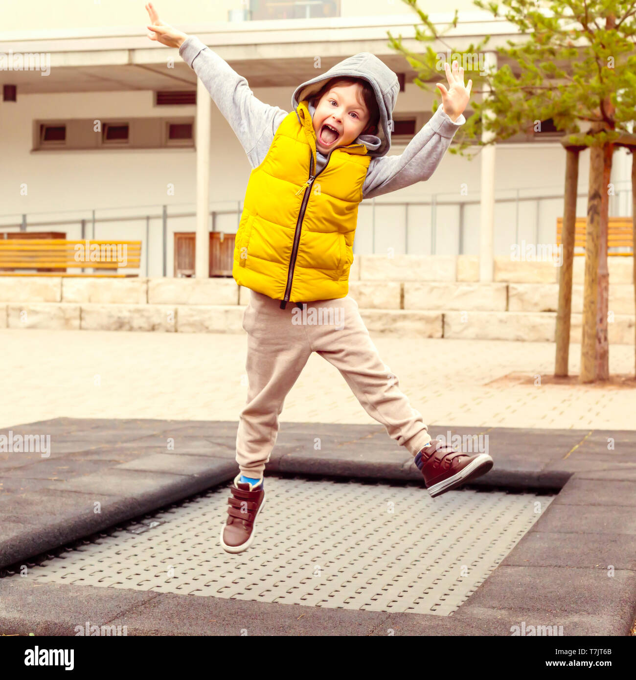 Happy child, active five year old boy plays outdoors in playground ...