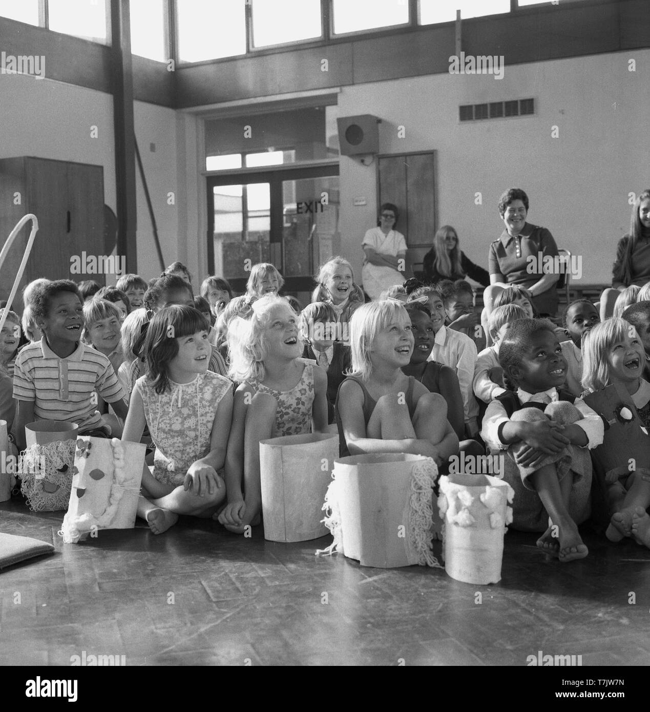 1960s, historical, excited young school children in the school hall ...