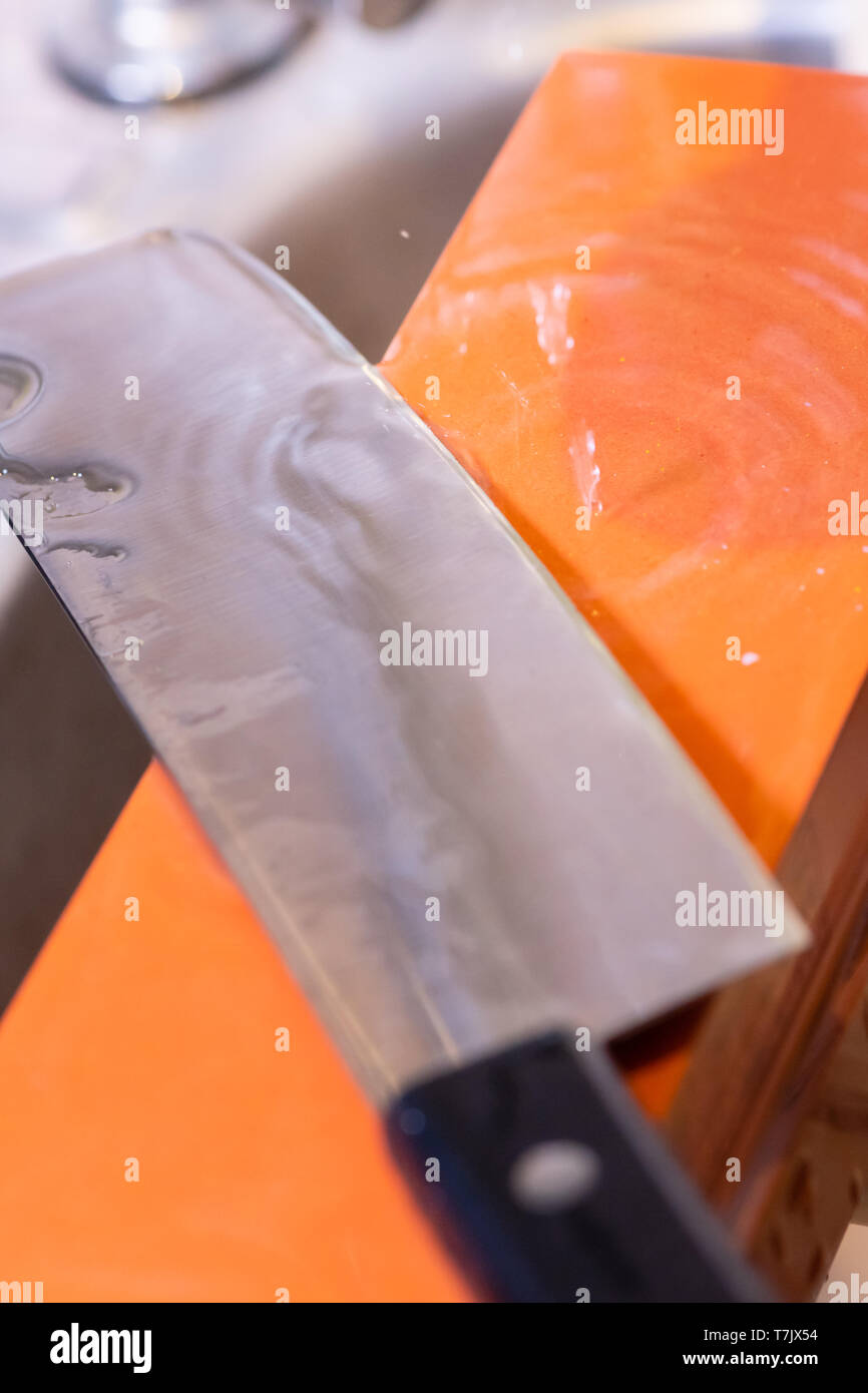 woman professional chef hands hold knife for whetting on whetstone ...