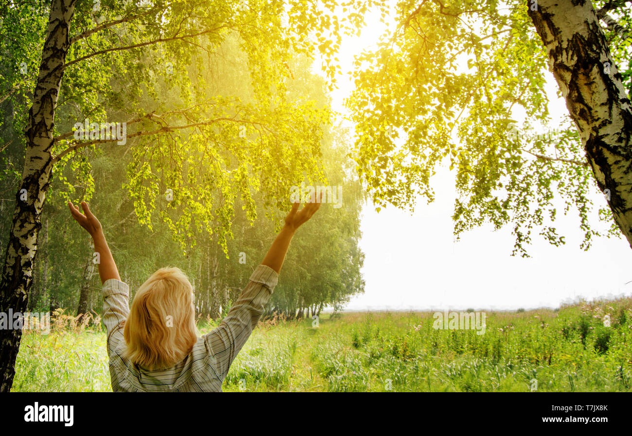 A woman near trees raised their hands. The concept of ecology and ...