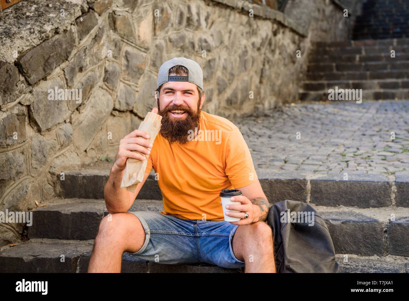 Hungry man snack. Junk food. Guy eating hot dog. Man bearded enjoy ...