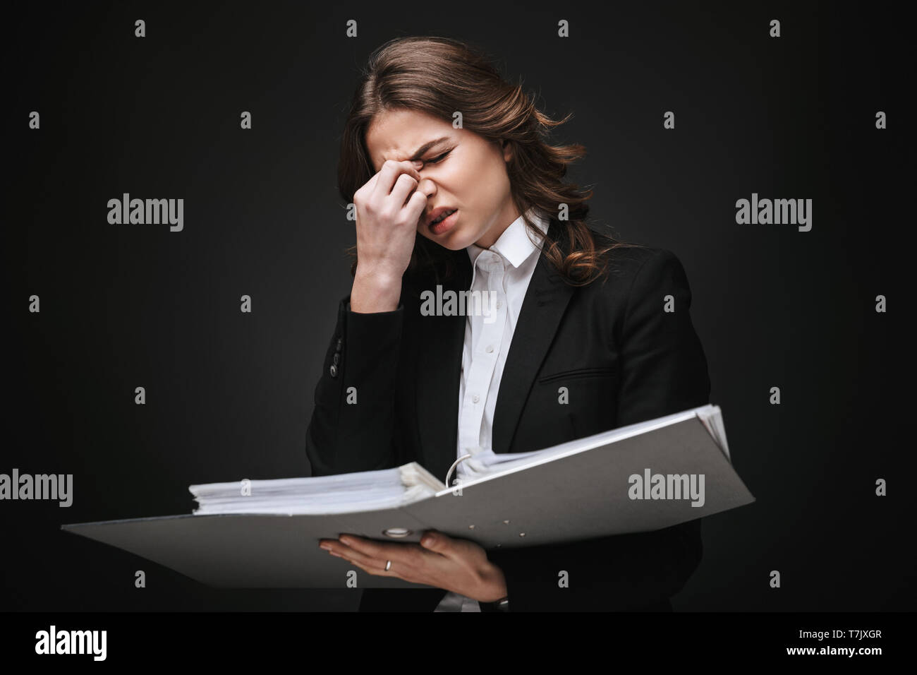 Portrait of a tired busy young businesswoman wearing formal suit ...