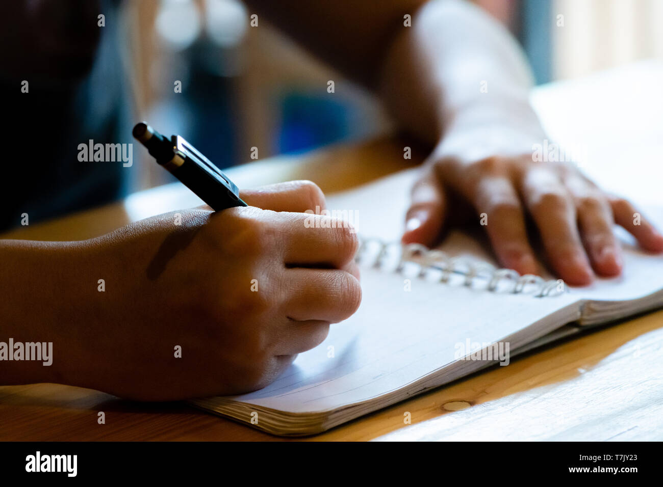 female hand with pencil writing on notebook at coffee shop.woman ...