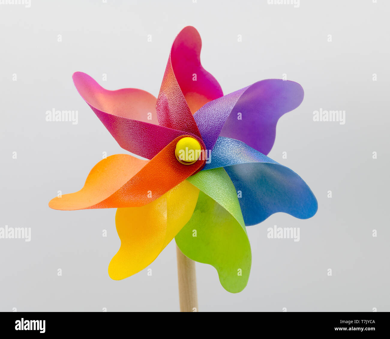 A stationary multi-coloured toy windmill on an isolated white ...