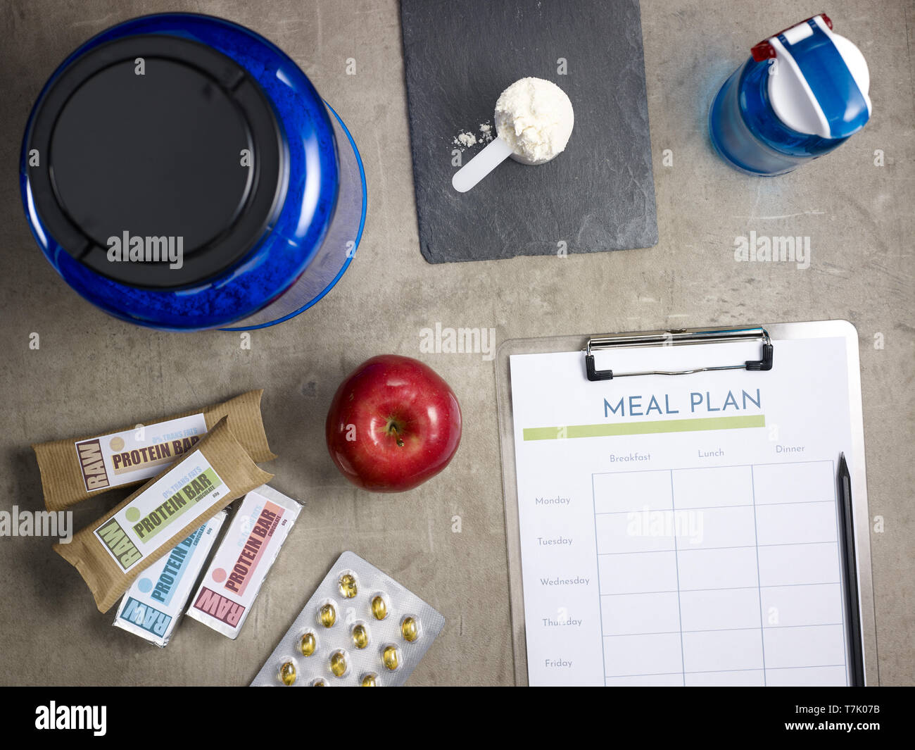 Closeup on big blue protein jar, shaker, measuring spoon with powder ...