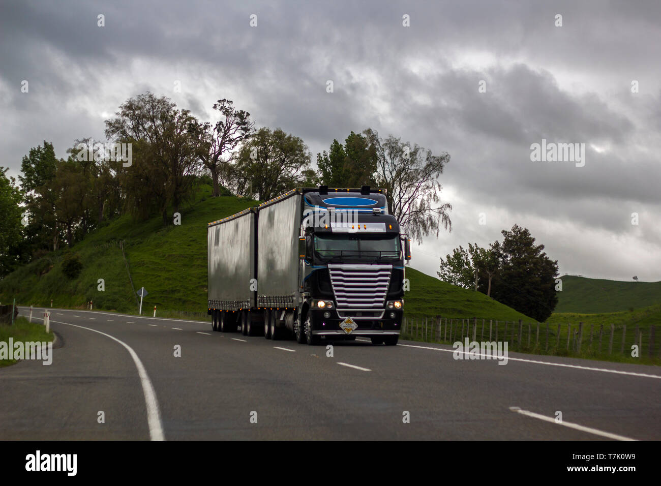 Truck driving on road in rural landscape Stock Photo - Alamy