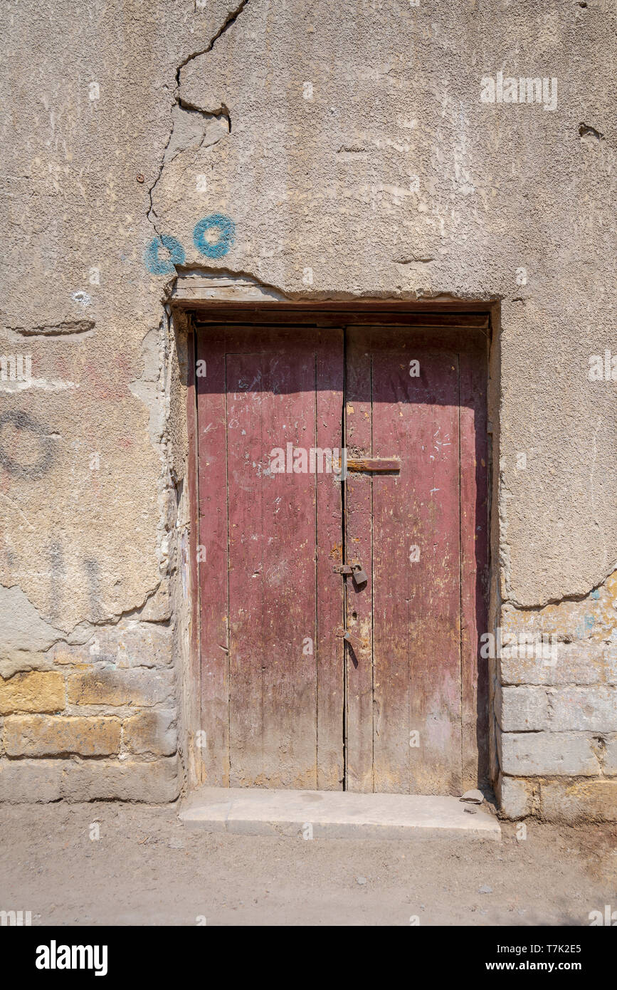 Broken wooden door on grunge stone bricks wall in abandoned Darb El ...