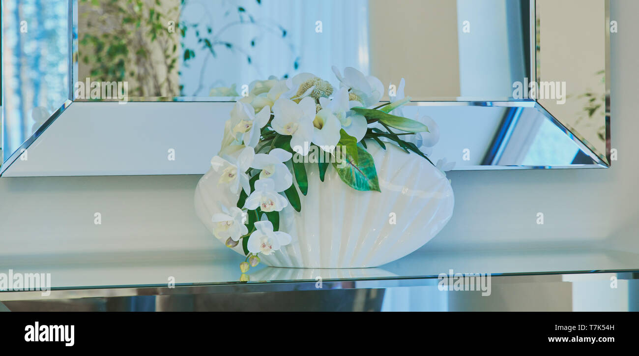 interior room lamp vase with flowers and a decorative mirror on a light ...