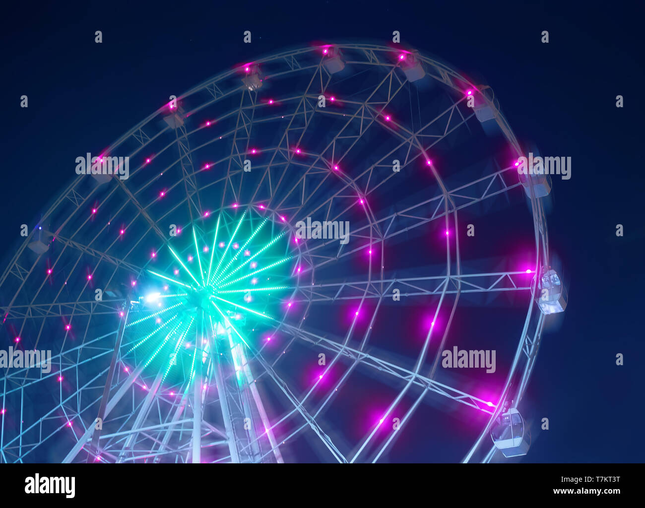 Carnival ride showing a spinning ferris wheel in action- long exposure ...