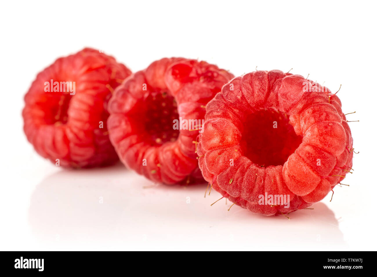 Group of three whole fresh red raspberry in row isolated on white ...