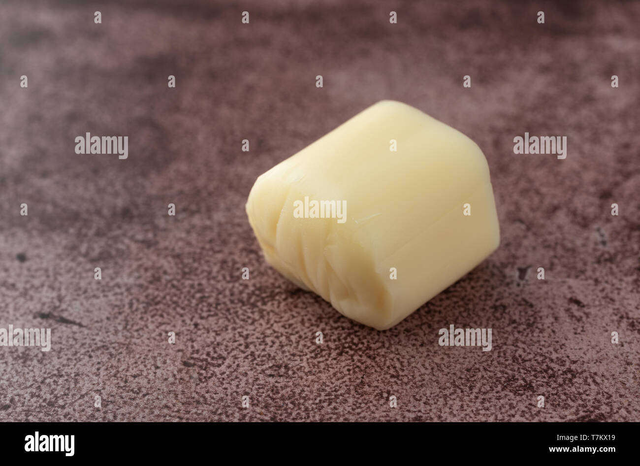 A small piece of mozzarella string cheese on a red background ...