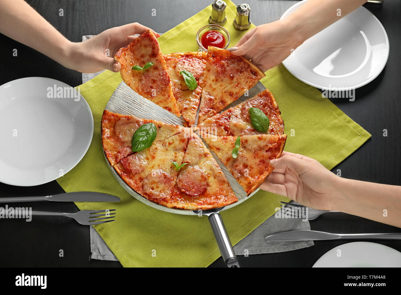 Women eating tasty pepperoni pizza at table Stock Photo - Alamy