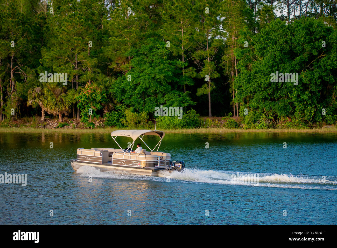 Orlando, Florida. April 02, 2019. Bay boat at blue lake on green forest ...