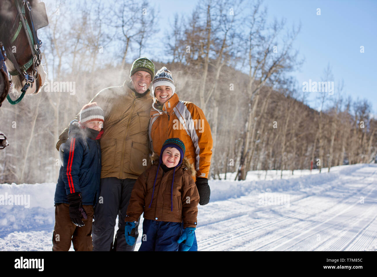 Portrait of a happy family standing together in the snow Stock Photo ...