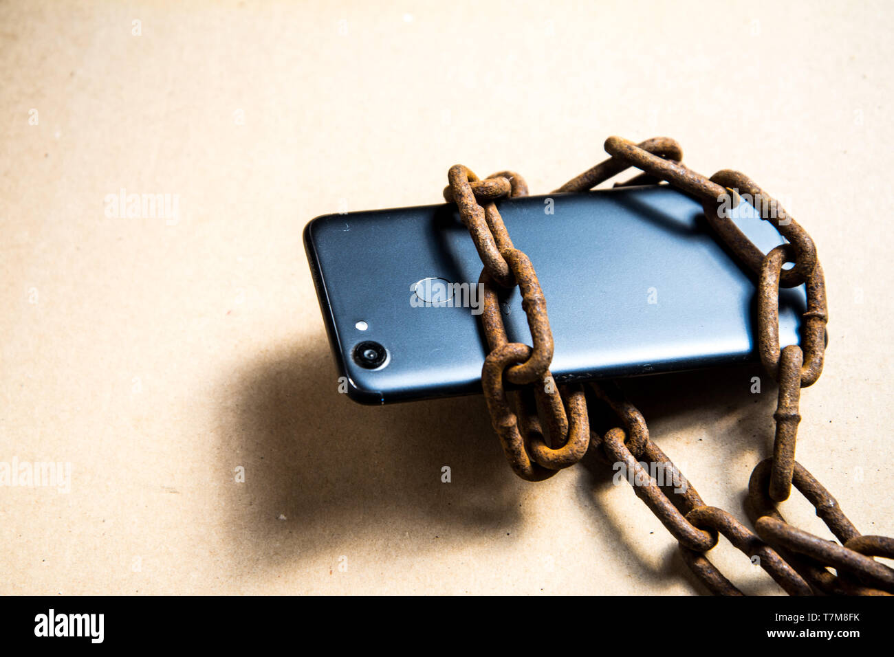 Smartphone in chains. Old rusty chains. Black smartphone Stock Photo ...
