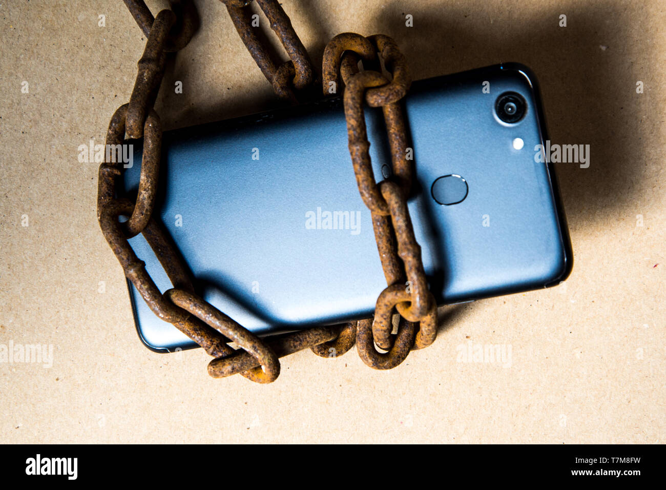Smartphone in chains. Old rusty chains. Black smartphone Stock Photo ...