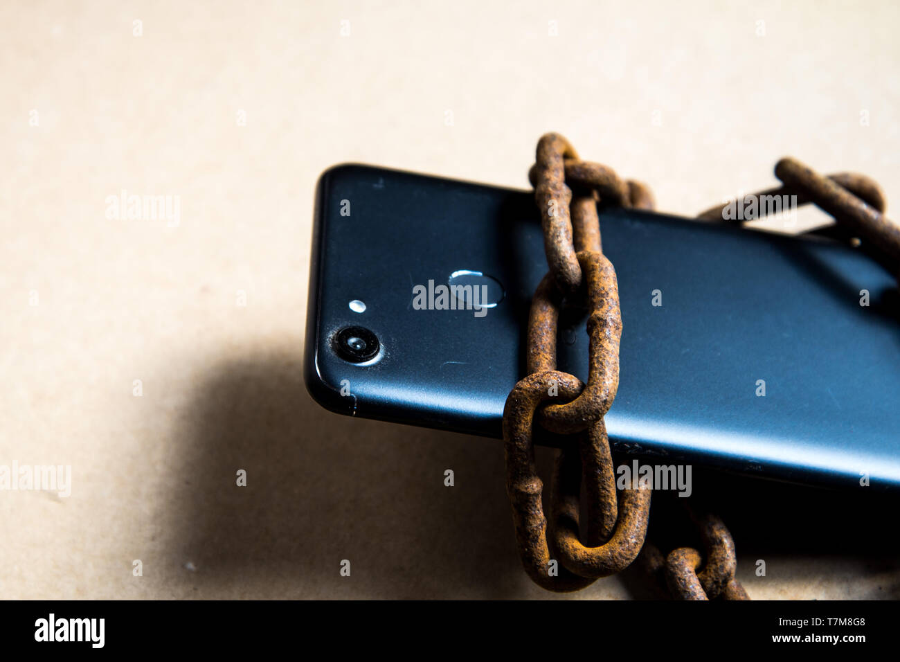Smartphone in chains. Old rusty chains. Black smartphone Stock Photo ...