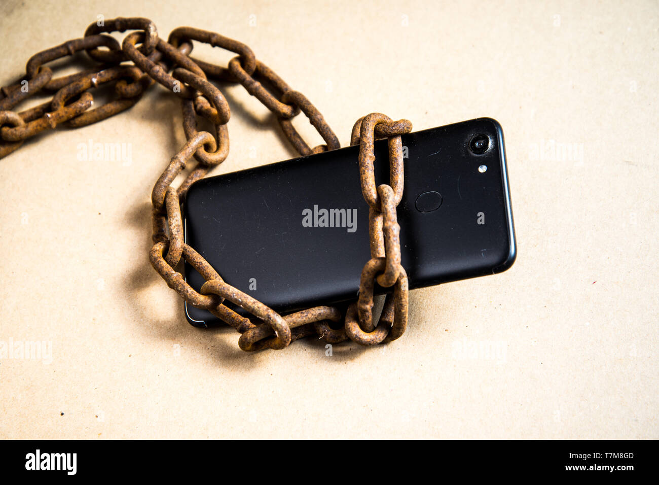 Smartphone in chains. Old rusty chains. Black smartphone Stock Photo ...