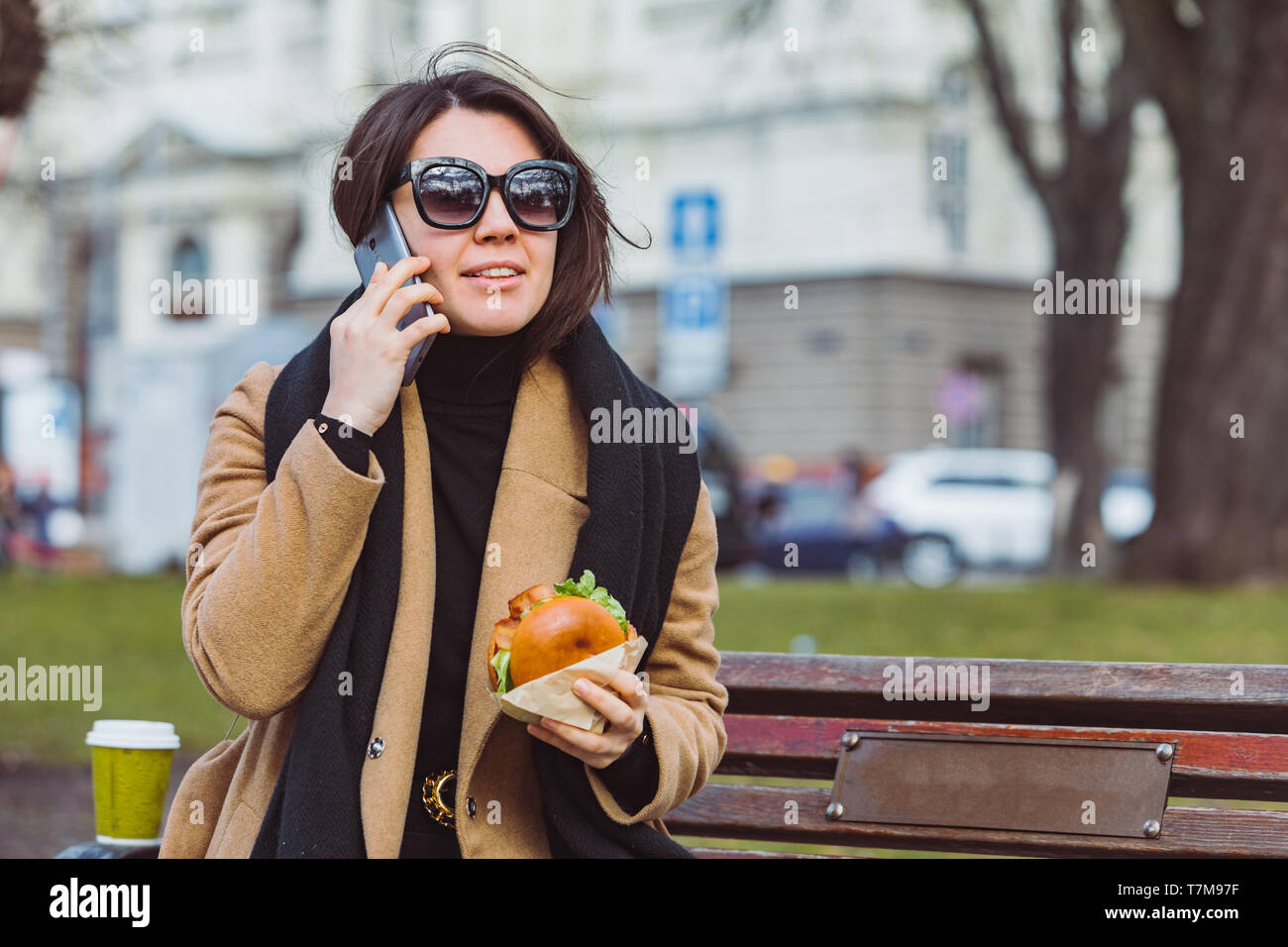 young beauty business woman eating fast food and working on phone while ...