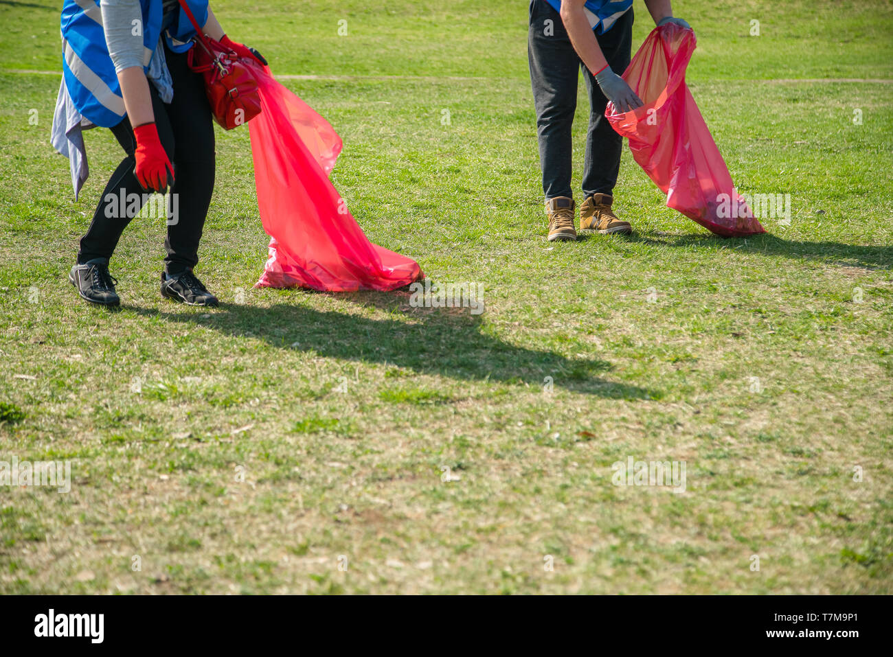 Man and woman volunteer wearing picking up trash and plastic waste in ...