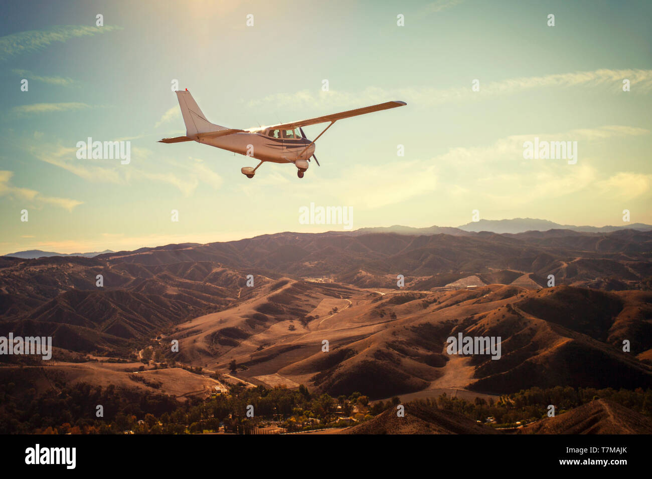 Small single engine airplane flying in the gorgeous sunset sky above ...