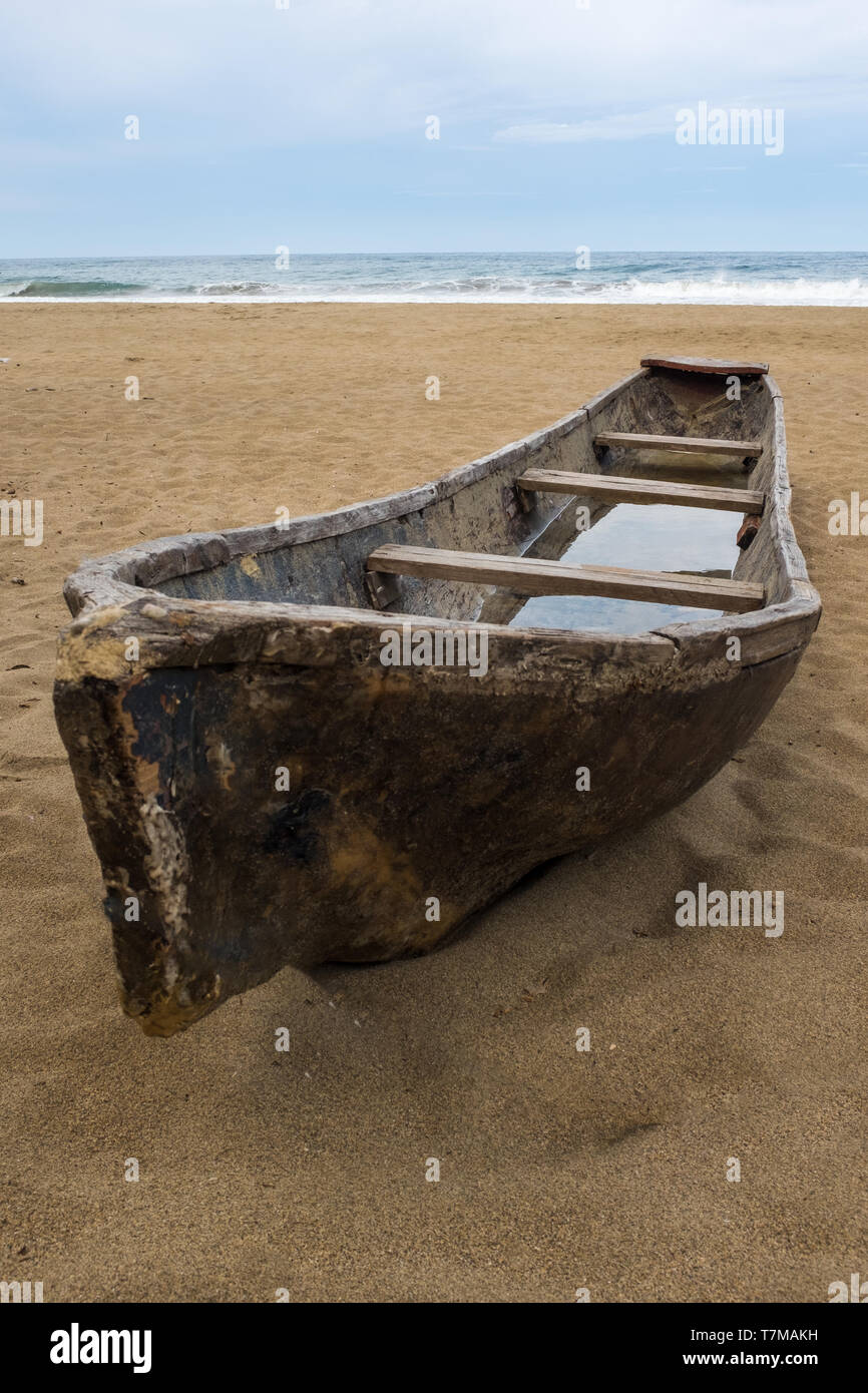 A rustic traditional dug-out canoe sitting on the beach at Puerto Viejo ...